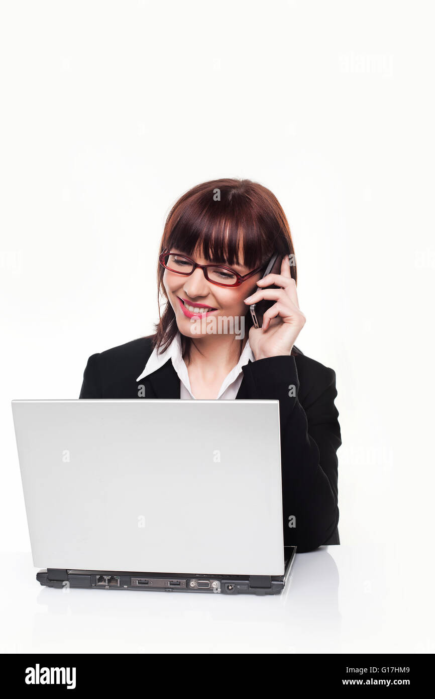 Businesswoman looking down at her laptop working while also listening ...