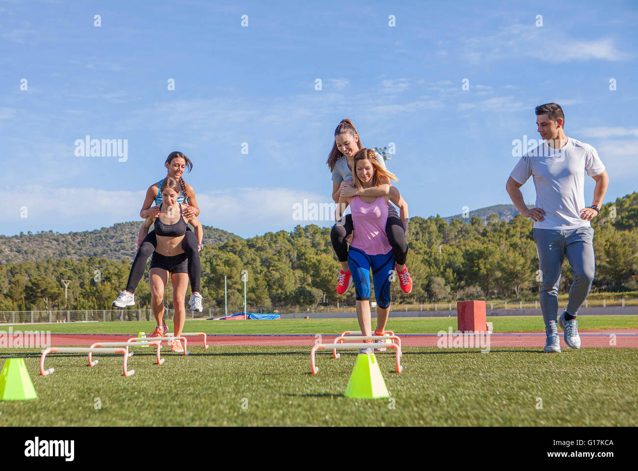 fitness class piggyback race with instructor Stock Photo - Alamy