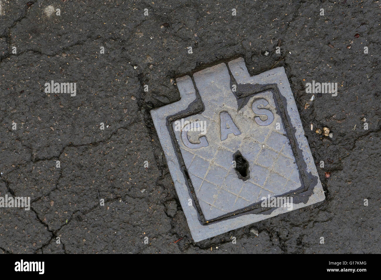 Small square metal gas sewer cover on a city street Stock Photo - Alamy
