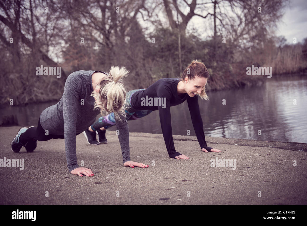 Women next to pond doing push ups Stock Photo - Alamy