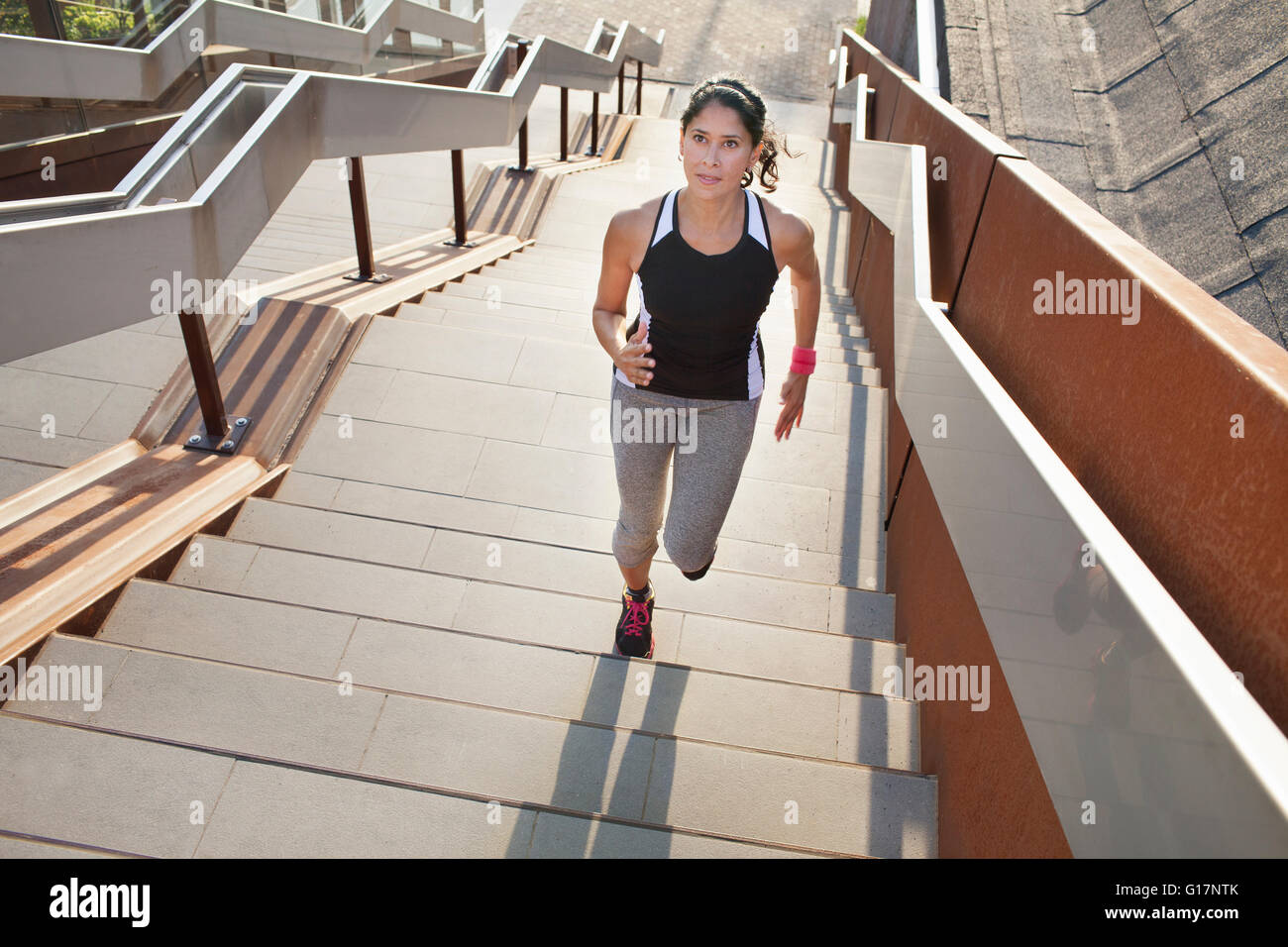 Female runner running up urban stairway Stock Photo - Alamy