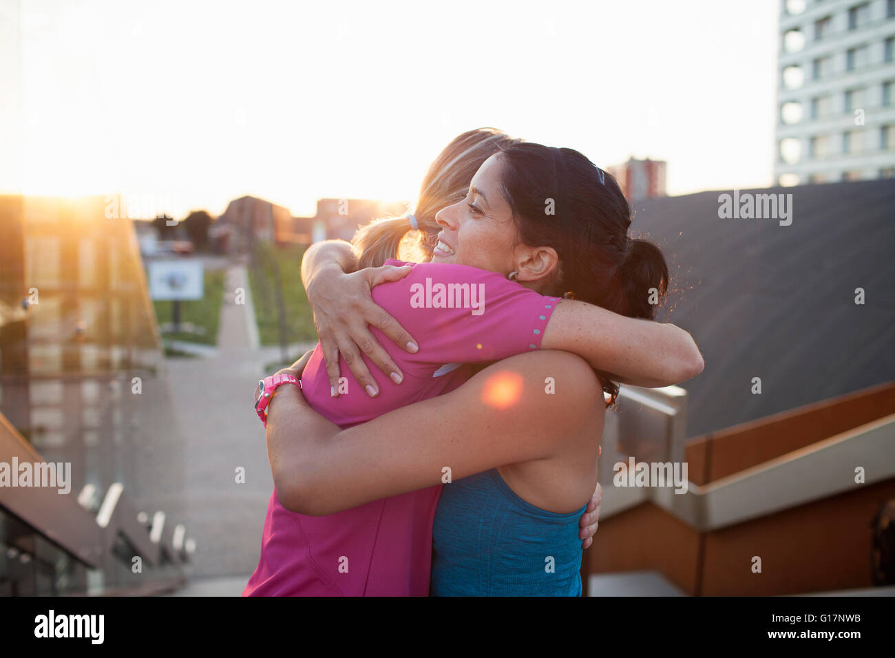 Two women training, hugging on stairway Stock Photo - Alamy