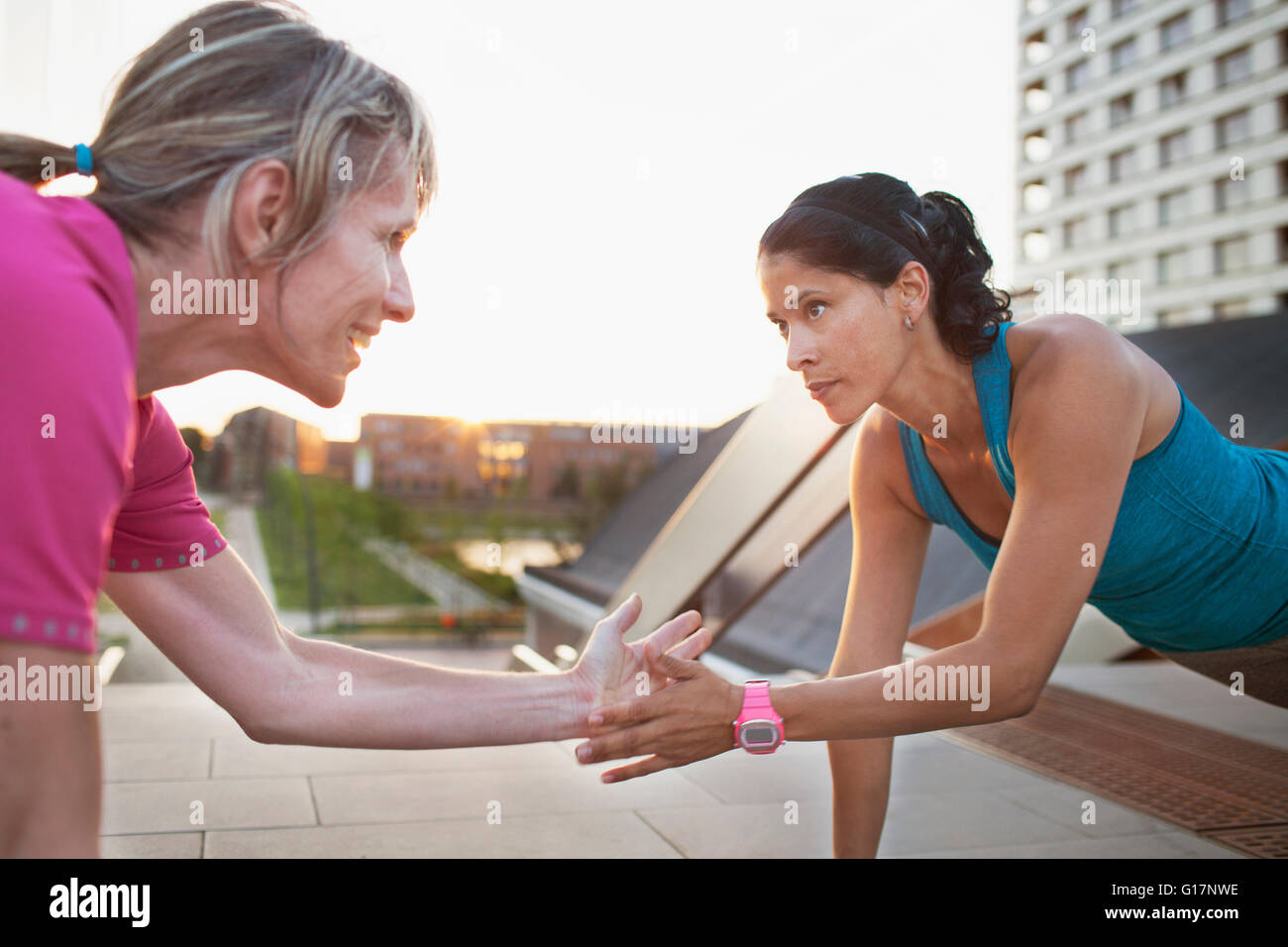 Two women training, doing push ups and shaking hands on stairway Stock ...
