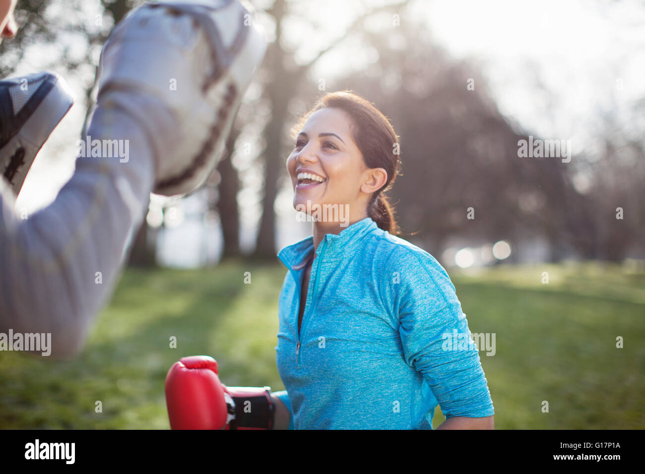 Young woman doing boxing training in park Stock Photo - Alamy