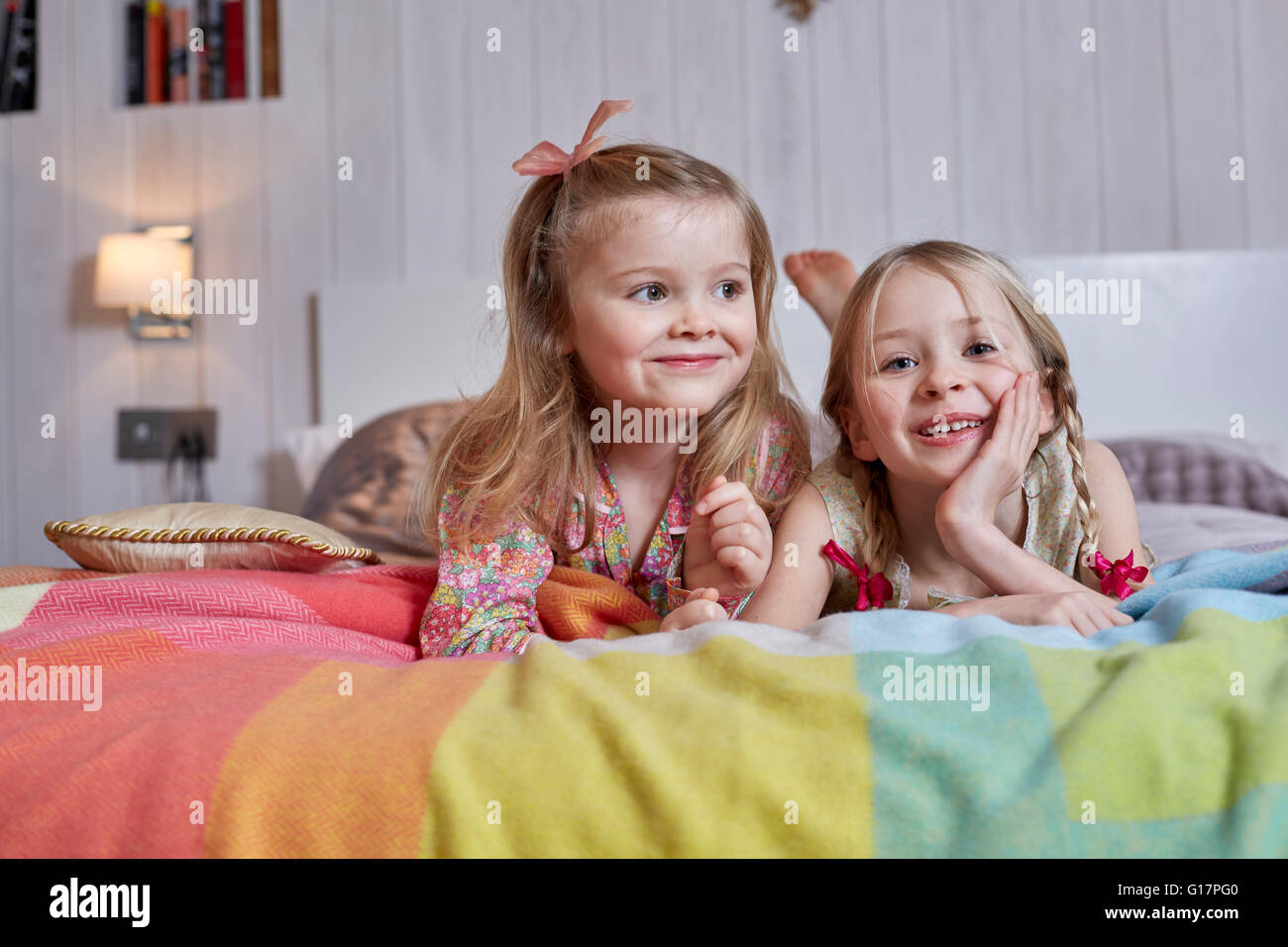 Girls lying on bed Stock Photo - Alamy