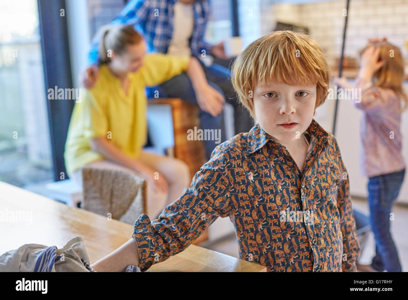 Boy wiping dining table, people in background Stock Photo - Alamy