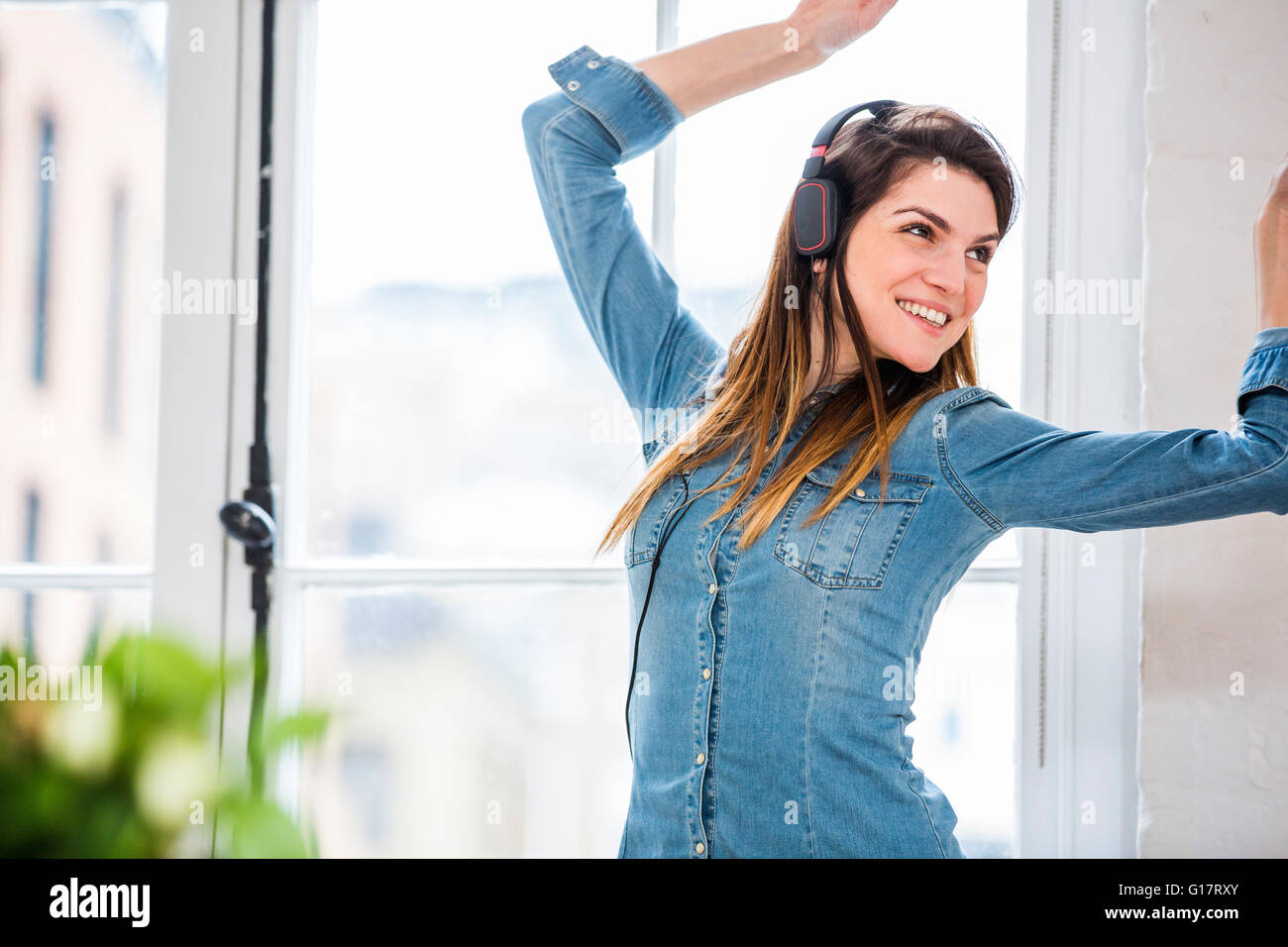 Young woman dancing in front of city apartment window Stock Photo - Alamy