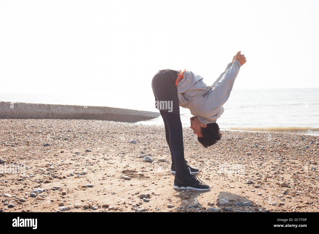 Young man training, bending forward on Brighton beach Stock Photo - Alamy