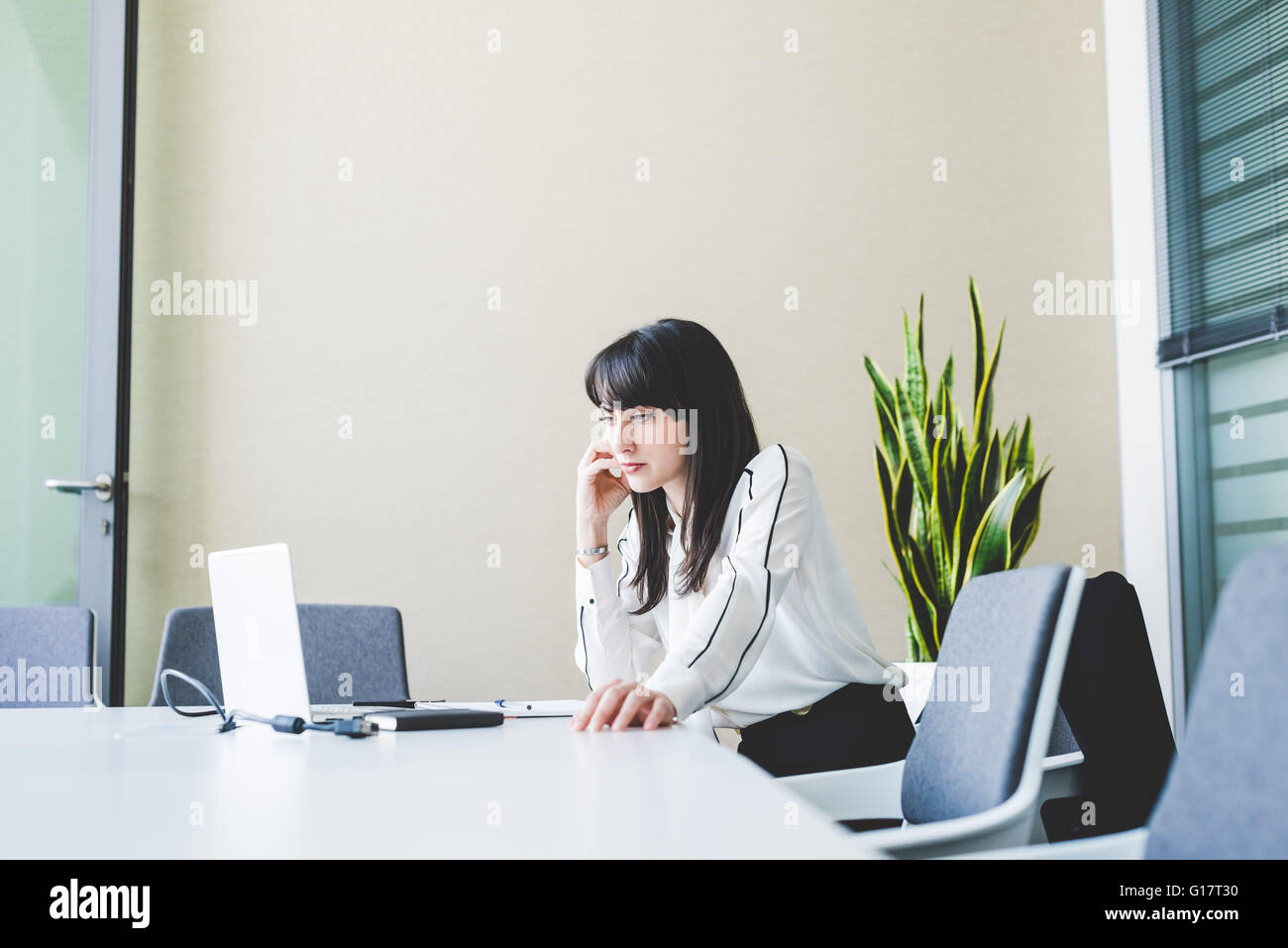 Businesswoman staring at laptop at office desk Stock Photo - Alamy