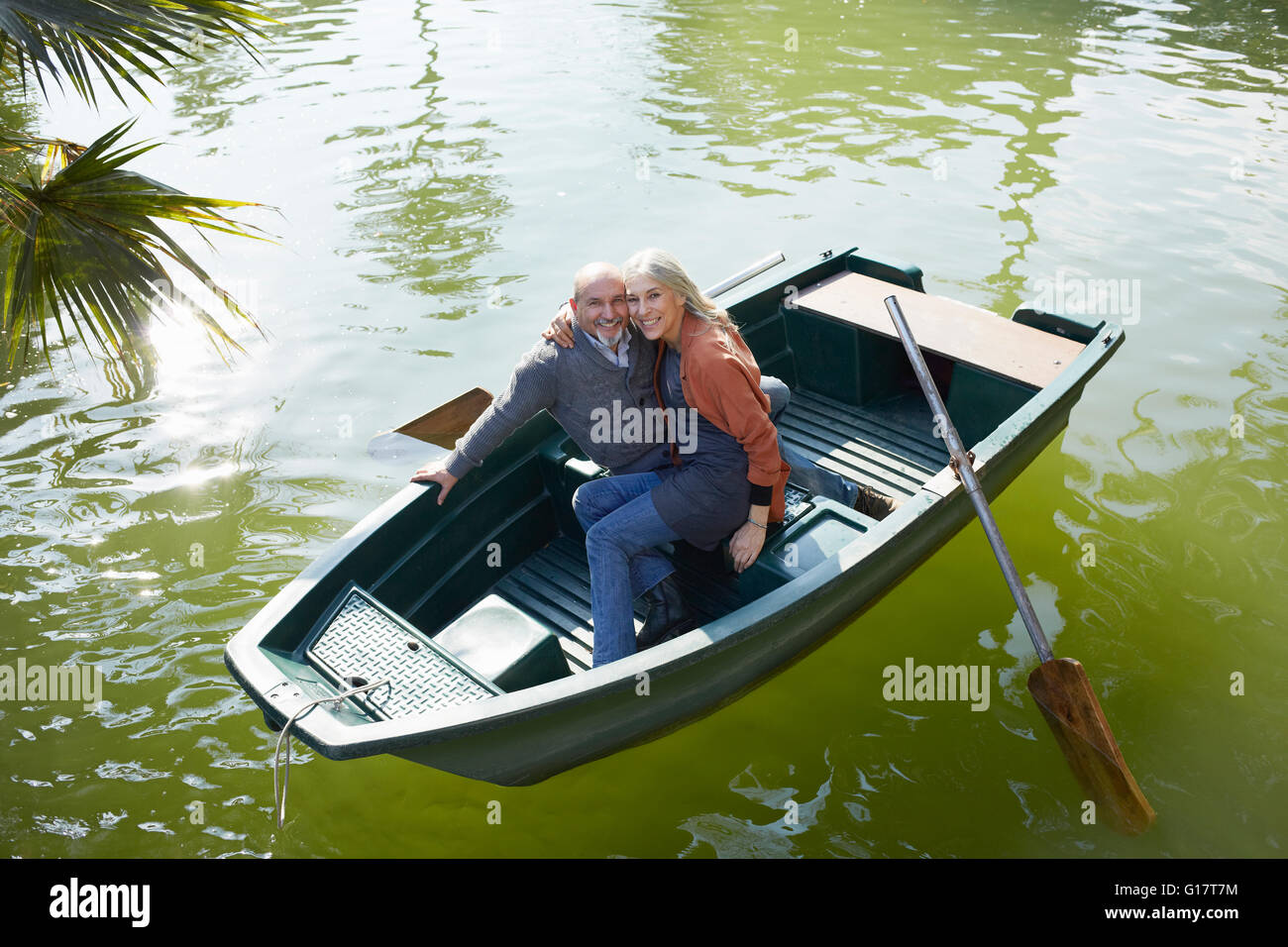 Couple in rowing boat on lake hugging looking at camera smiling Stock ...