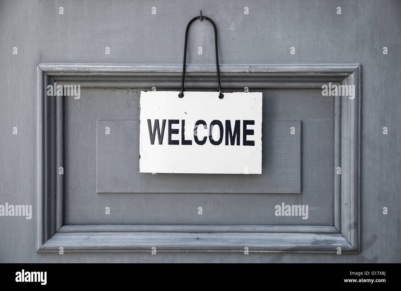 Welcome text plate hanging on gray wooden door Stock Photo - Alamy