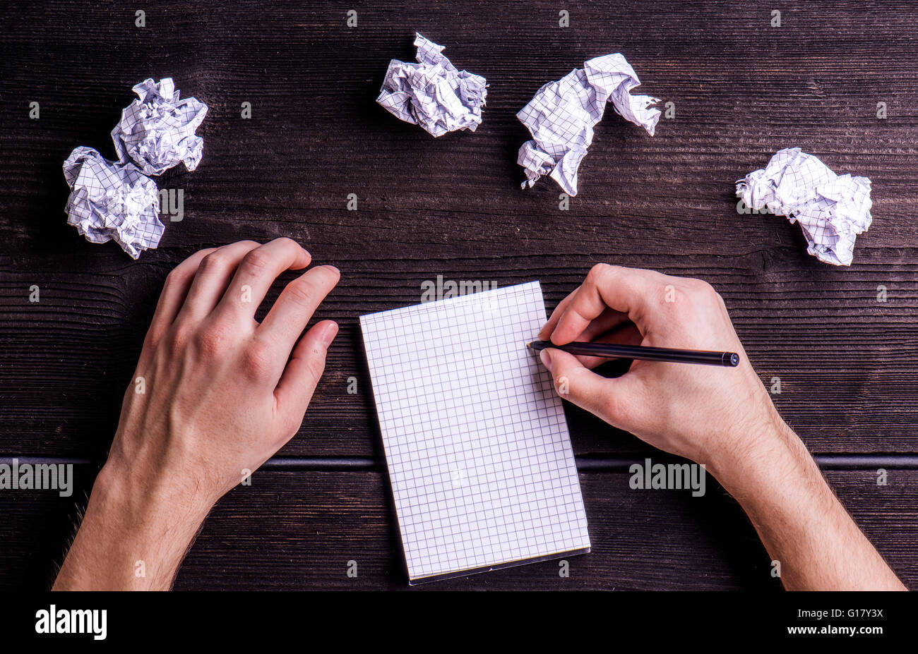 Office desk, man writing note, studio shot, wooden background Stock ...