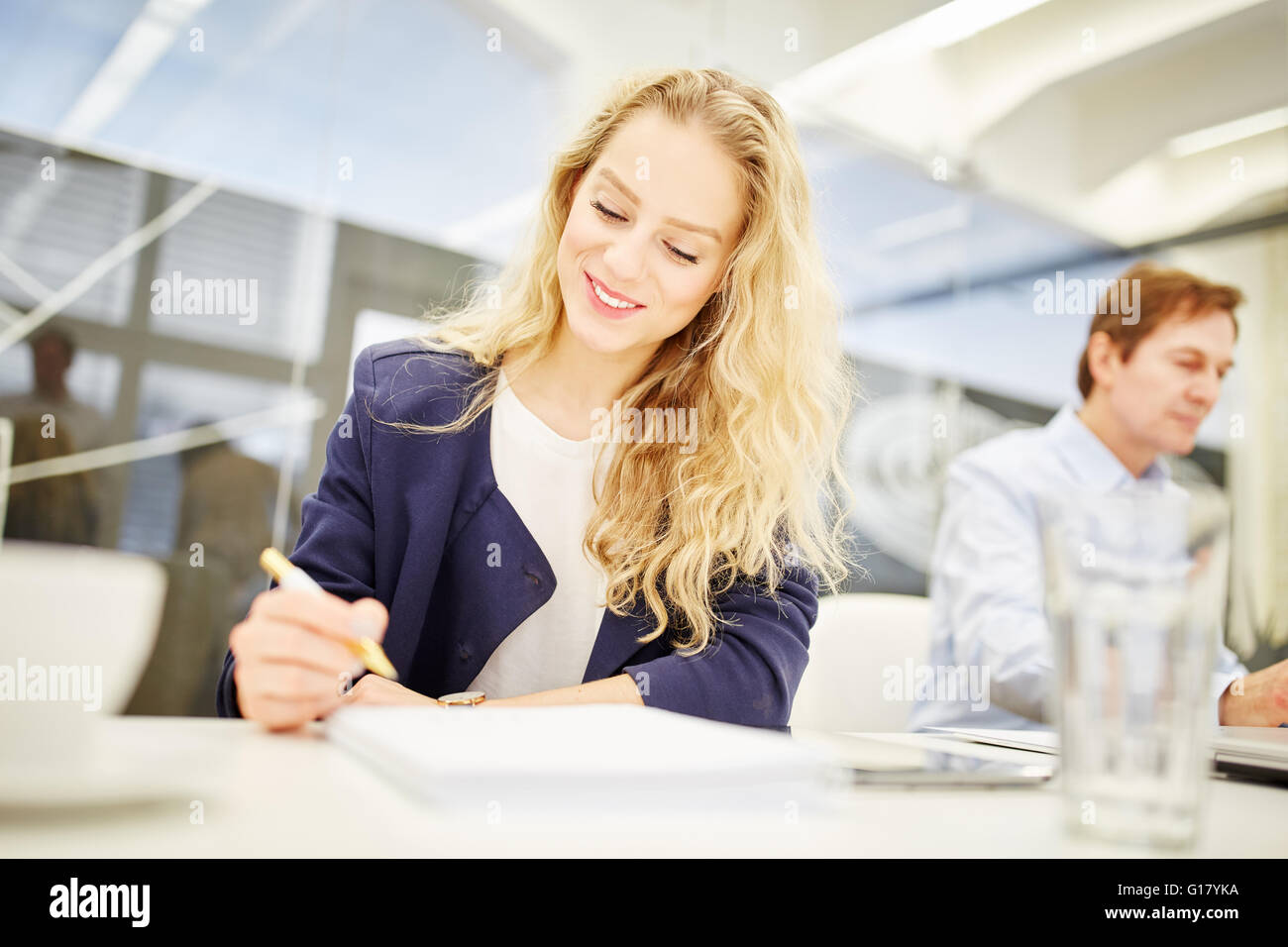 Businesswoman taking notes during a business meeting Stock Photo - Alamy
