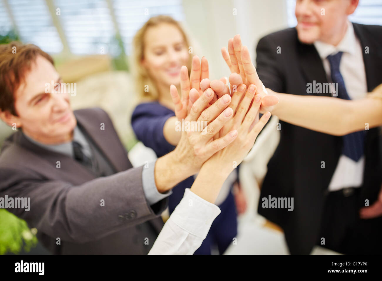 Hands of business people giving a high five to each other as sign of ...