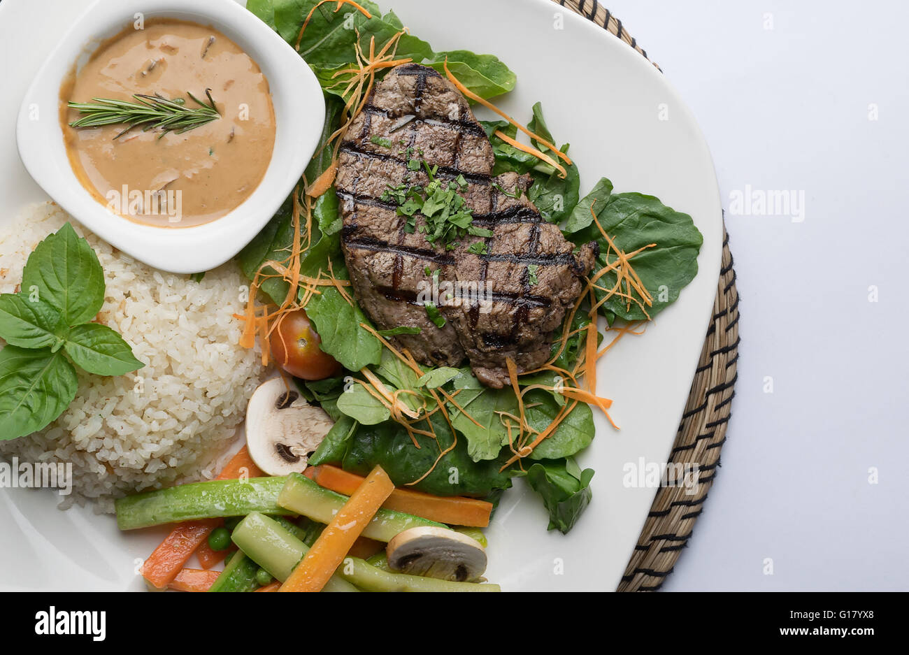 Thick cut beef fillet steak served with rice, vegetables, mushroom, and ...