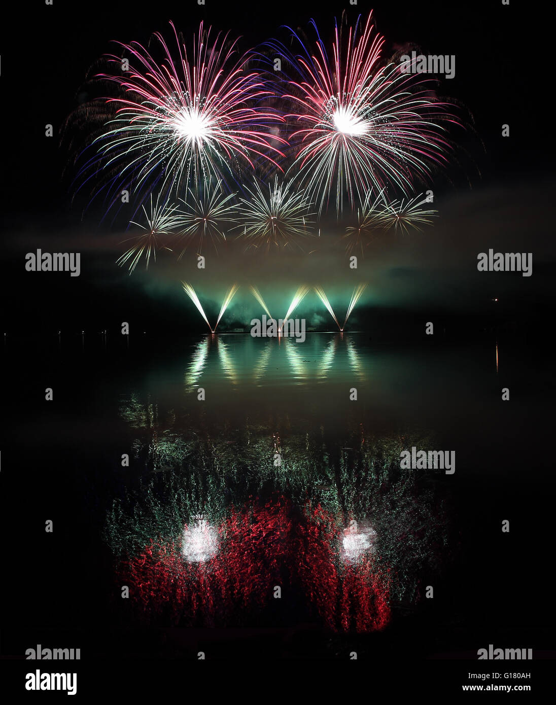 Colorful fireworks with reflection on lake and night sky in background ...