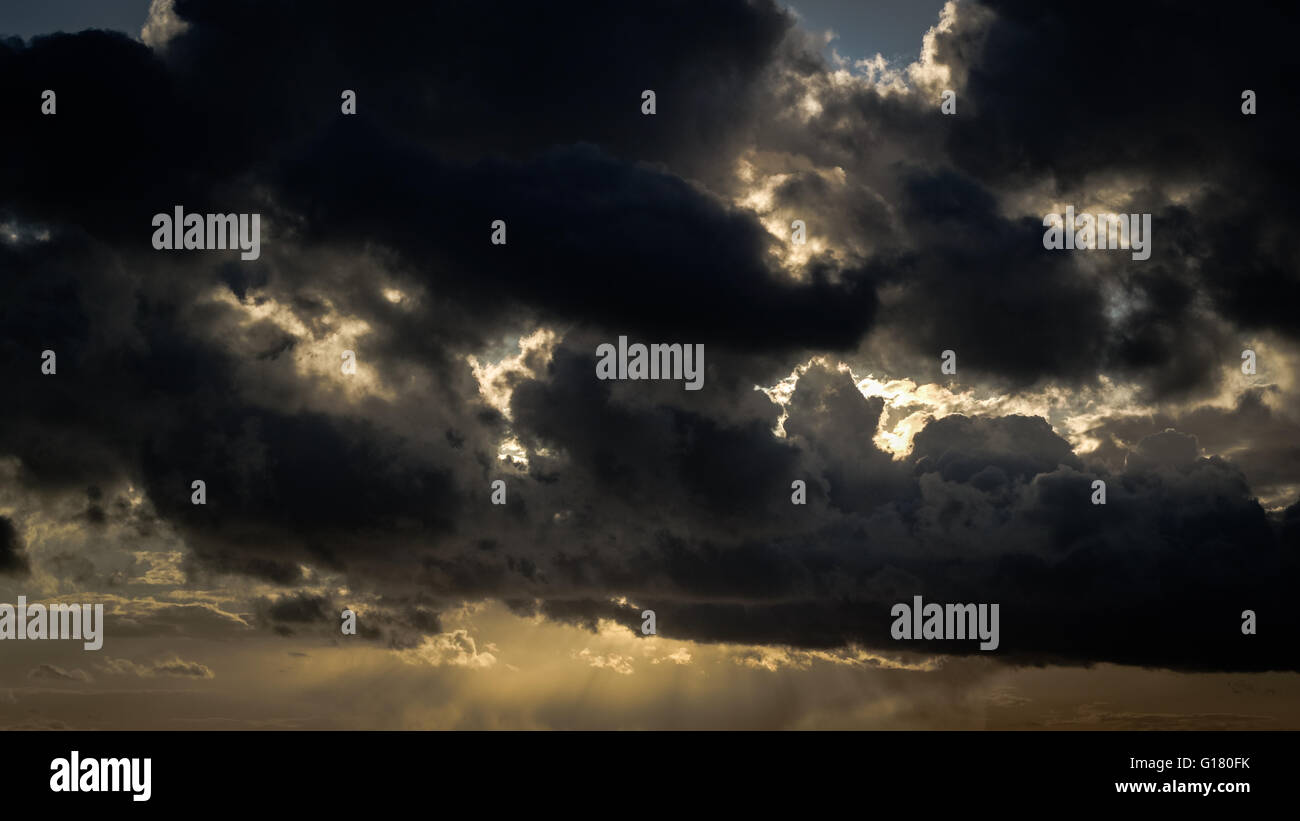A brooding backlit cloudy sky at sunset Stock Photo - Alamy