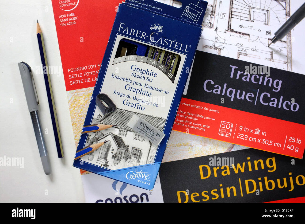 A flat lay of pencils, pens and drawing papers photographed against a ...