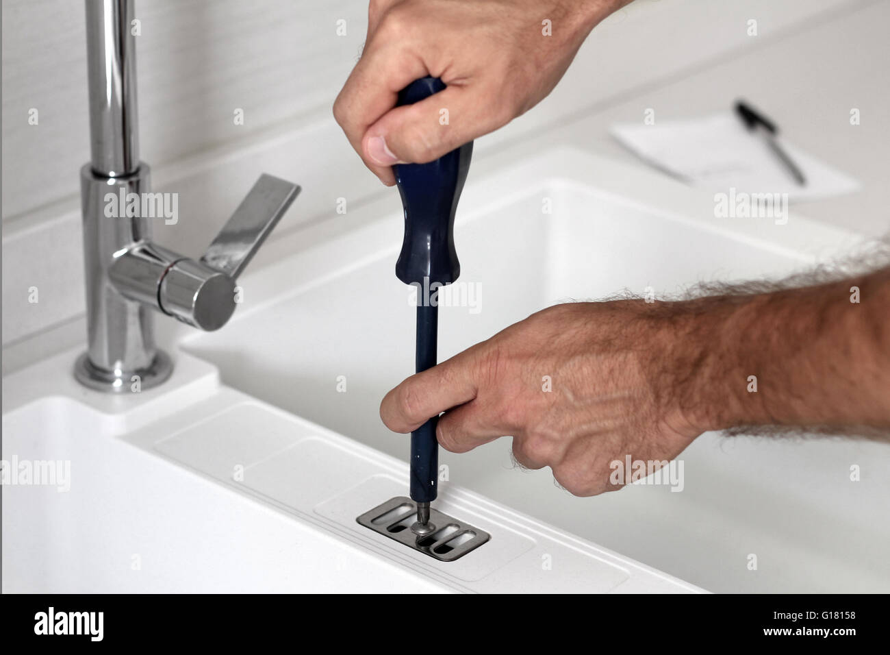 Repairman fixing a kitchen sink, construction and architecture concepts ...