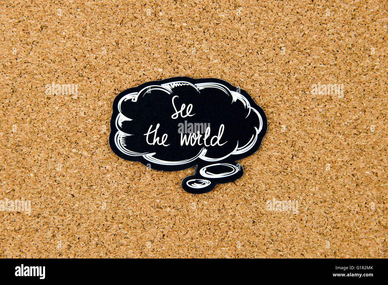 SEE THE WORLD written on black thinking bubble over cork board ...