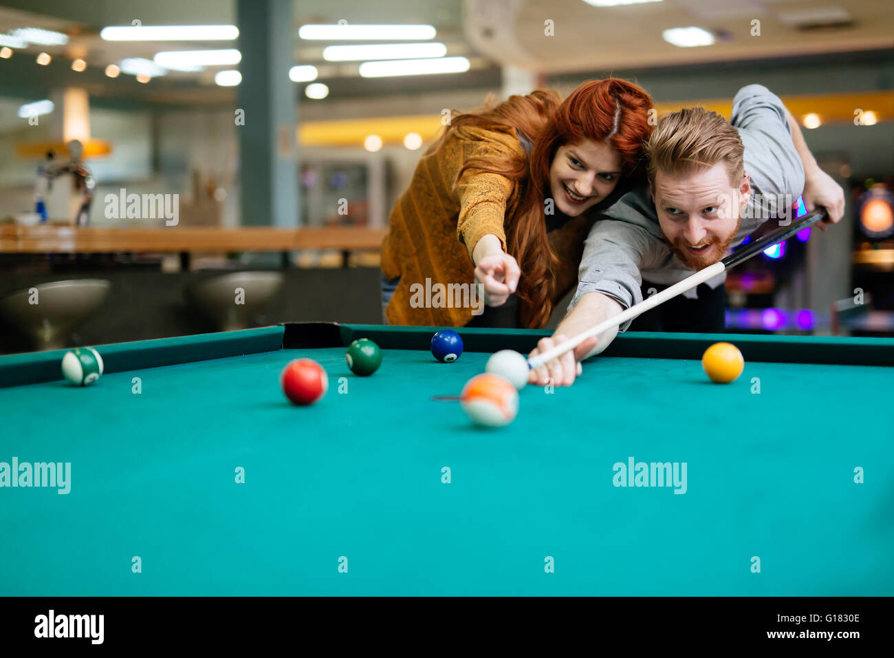 Beautiful happy couple playing billiards Stock Photo - Alamy