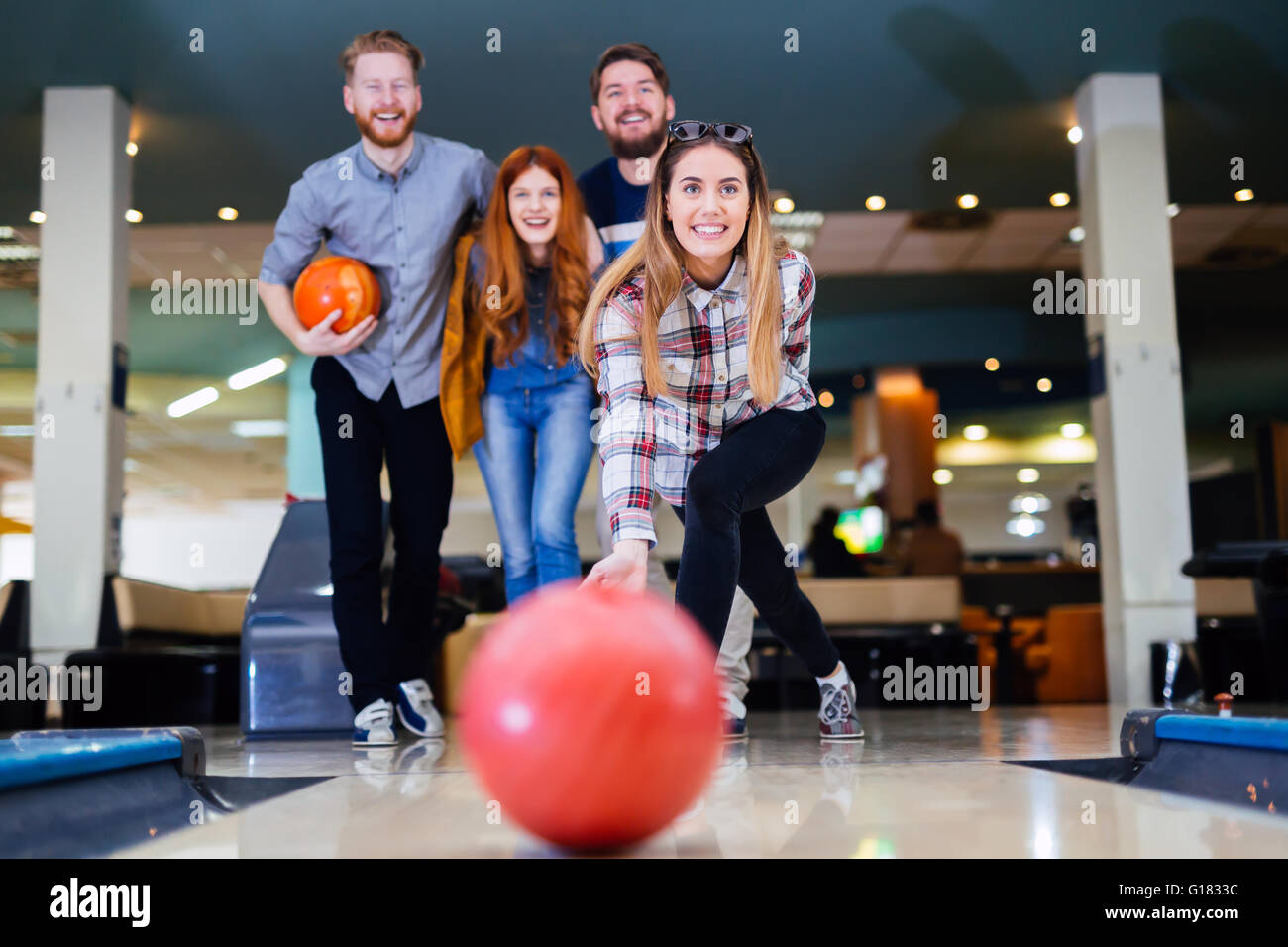 Friends enjoying recreational bowling at club Stock Photo - Alamy