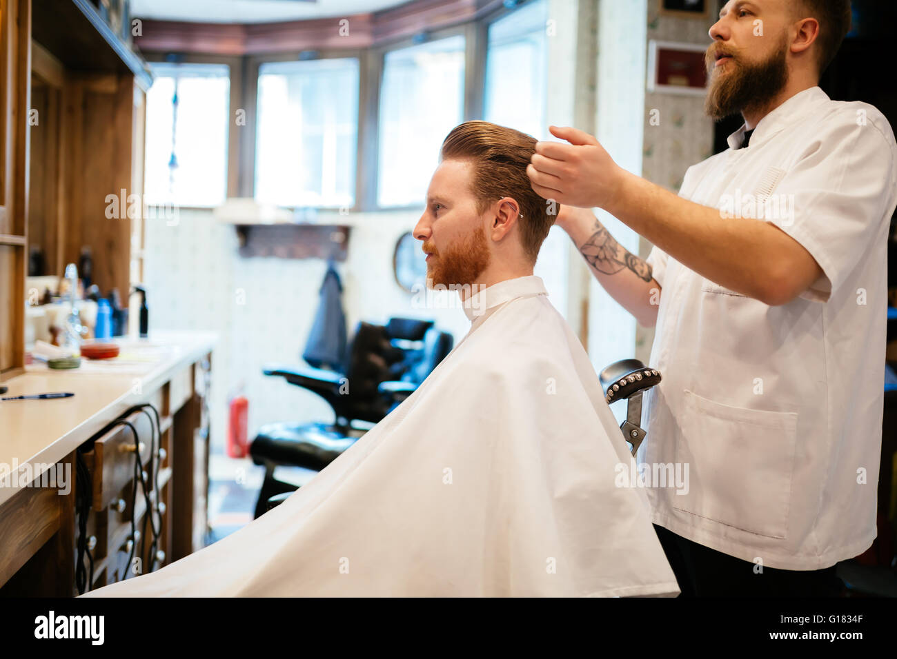 Male receiving hair beard treatment in barber shop Stock Photo - Alamy