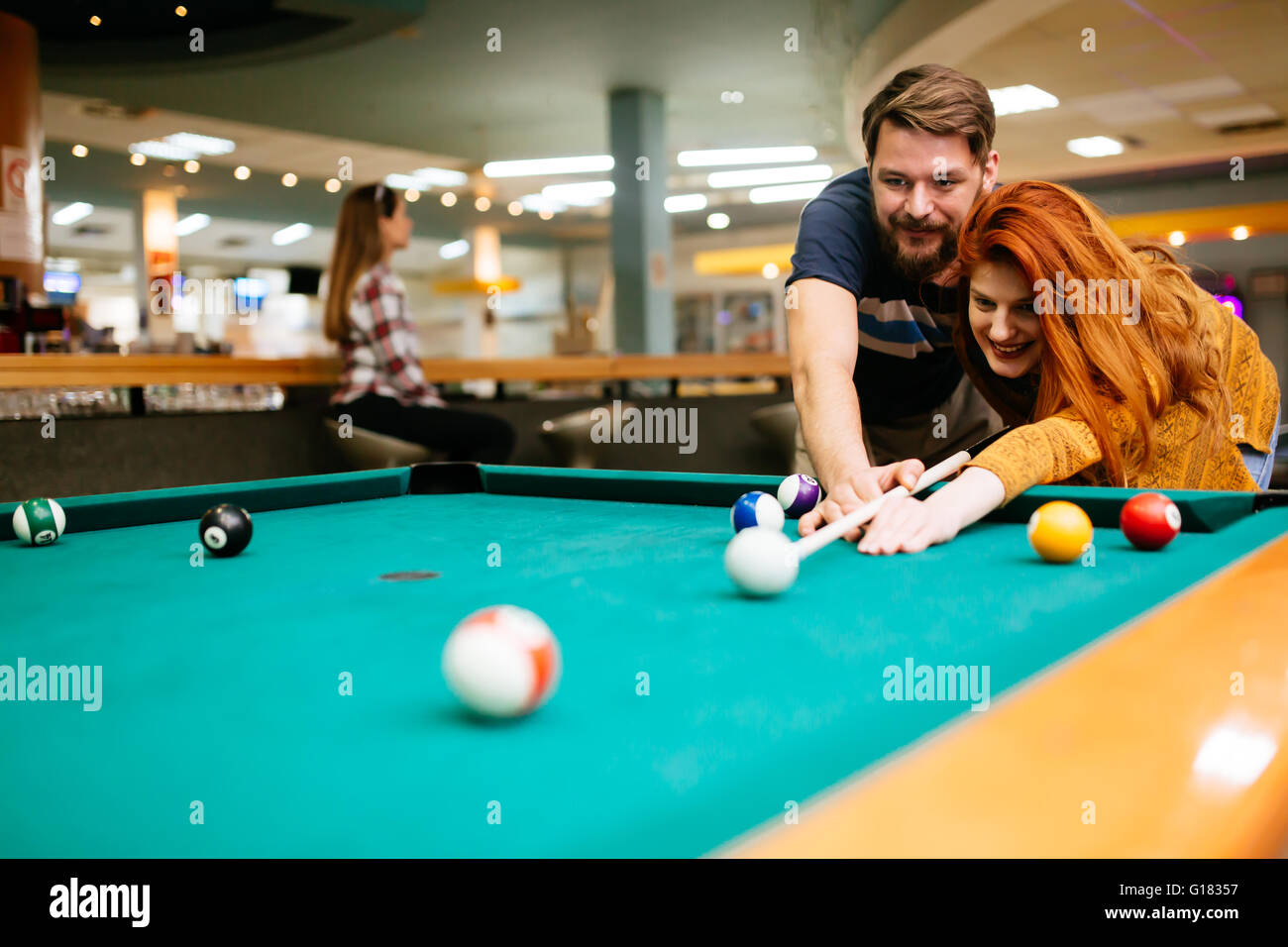 Beautiful happy couple playing billiards Stock Photo - Alamy