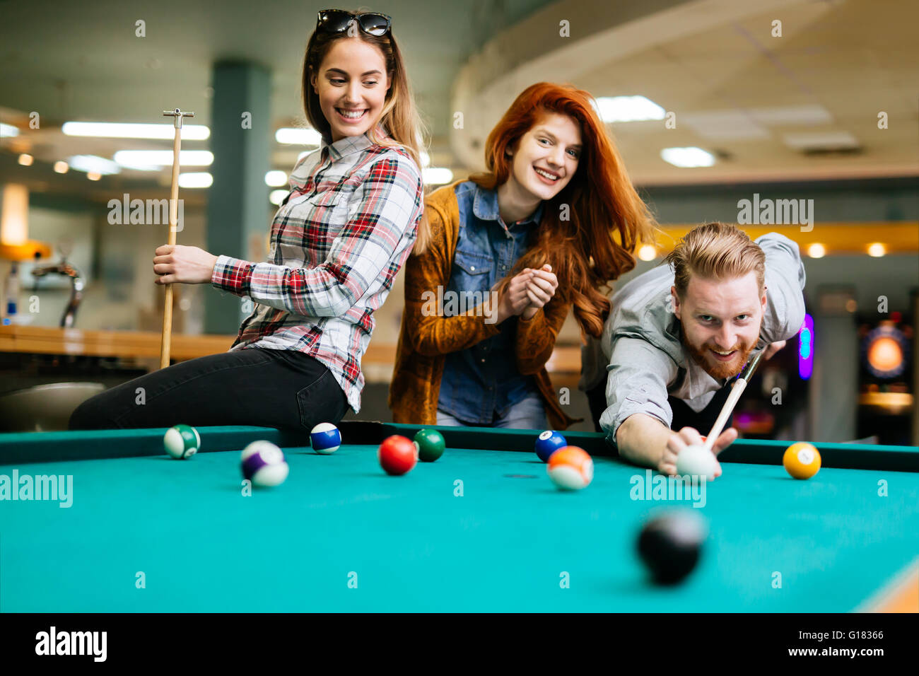 Happy friends enjoying playing pool together Stock Photo - Alamy