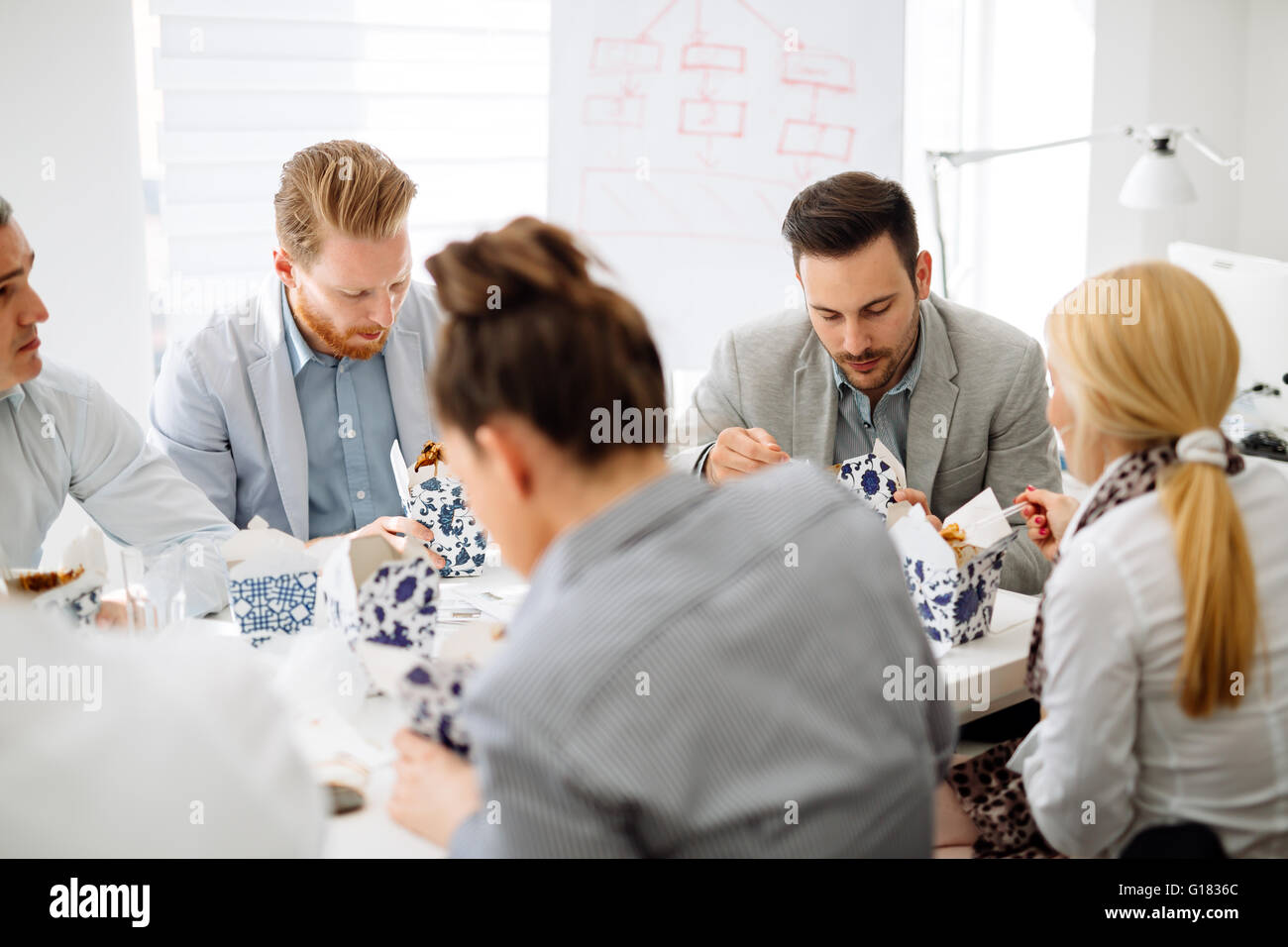 Colleagues eating in office during lunch break Stock Photo - Alamy