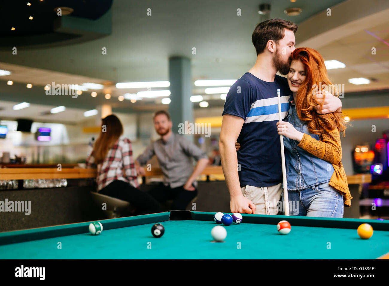Beautiful happy couple playing billiards Stock Photo - Alamy