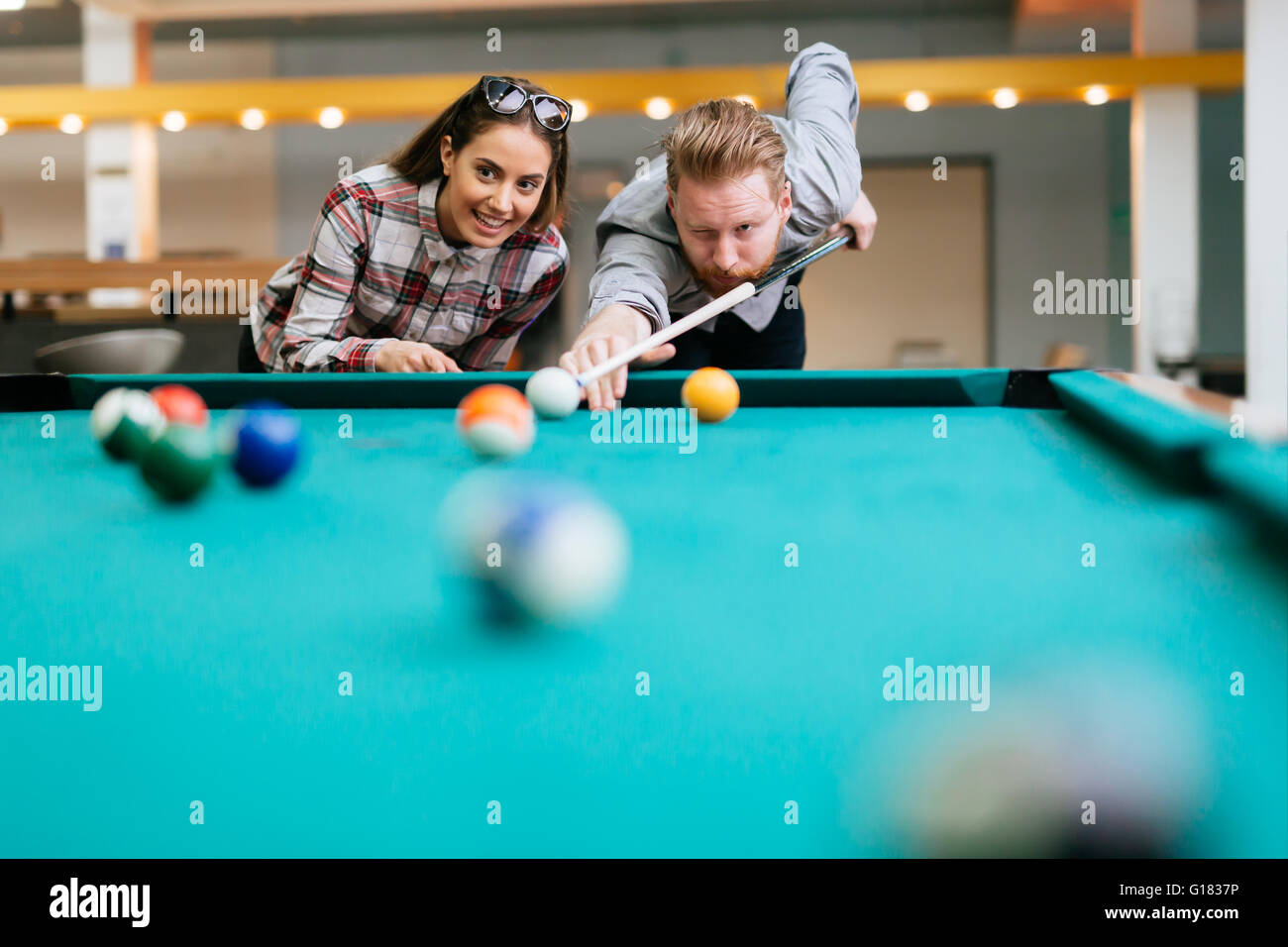 Beautiful happy couple playing billiards Stock Photo - Alamy