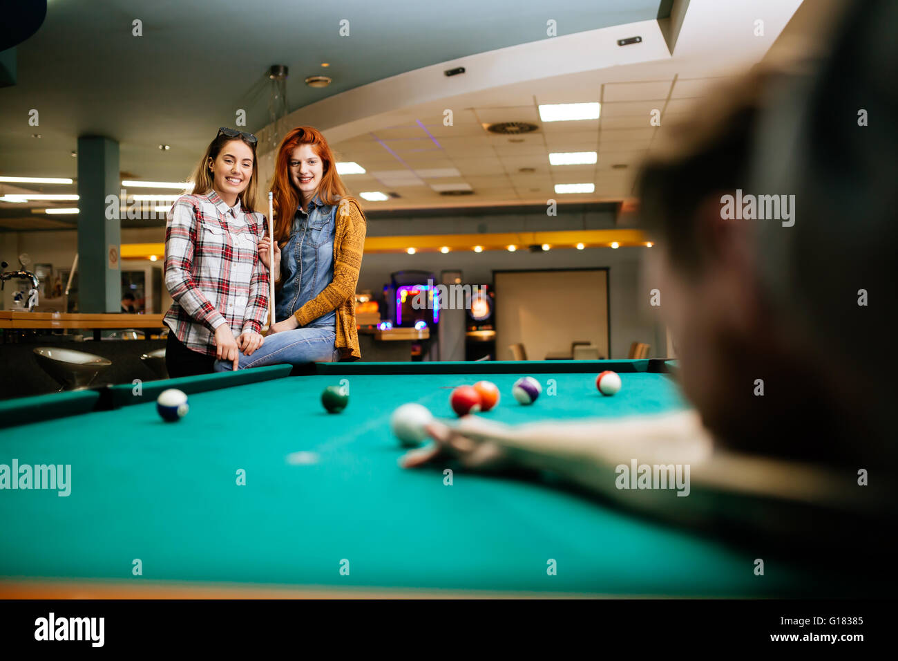 Happy friends enjoying playing pool together Stock Photo - Alamy
