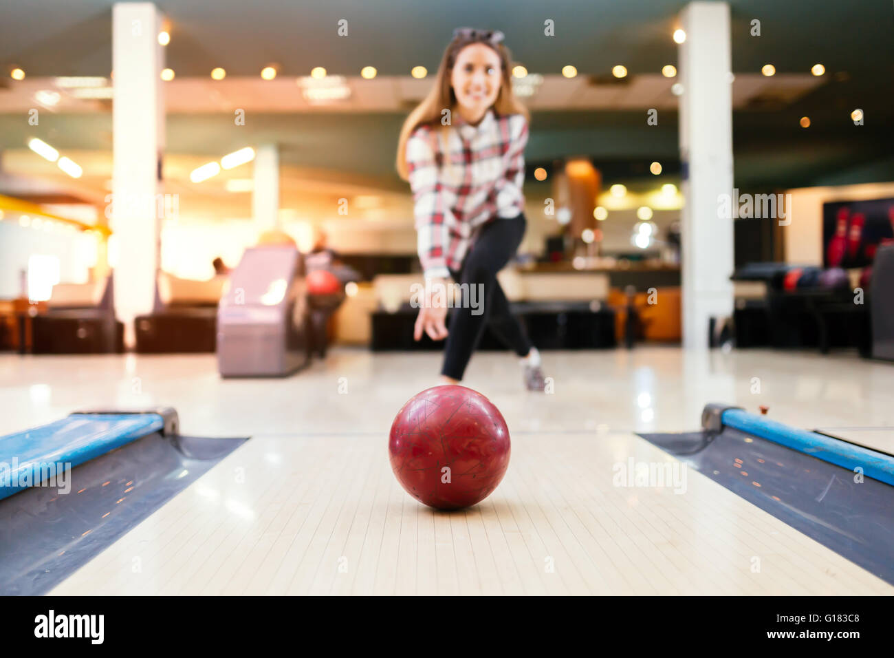 Woman throwing bowling ball in club Stock Photo - Alamy