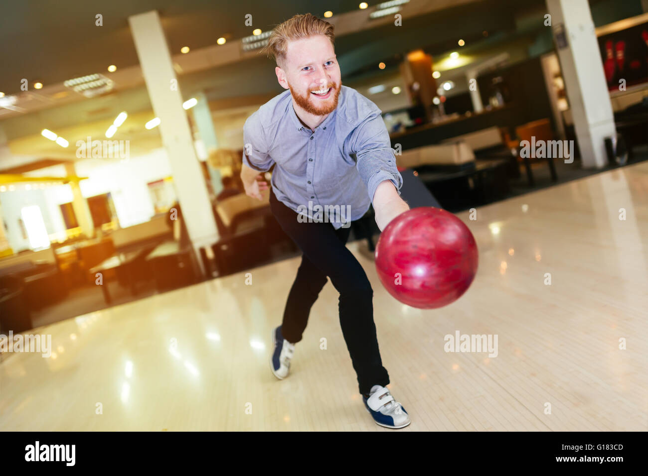 Handsome man bowling in club and throwing ball Stock Photo - Alamy