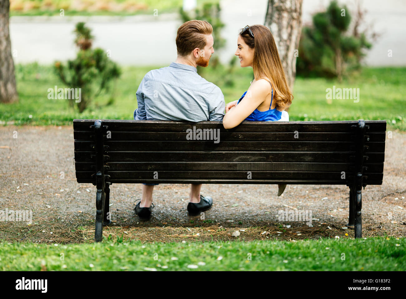 Romantic couple in love sitting on park bench Stock Photo - Alamy
