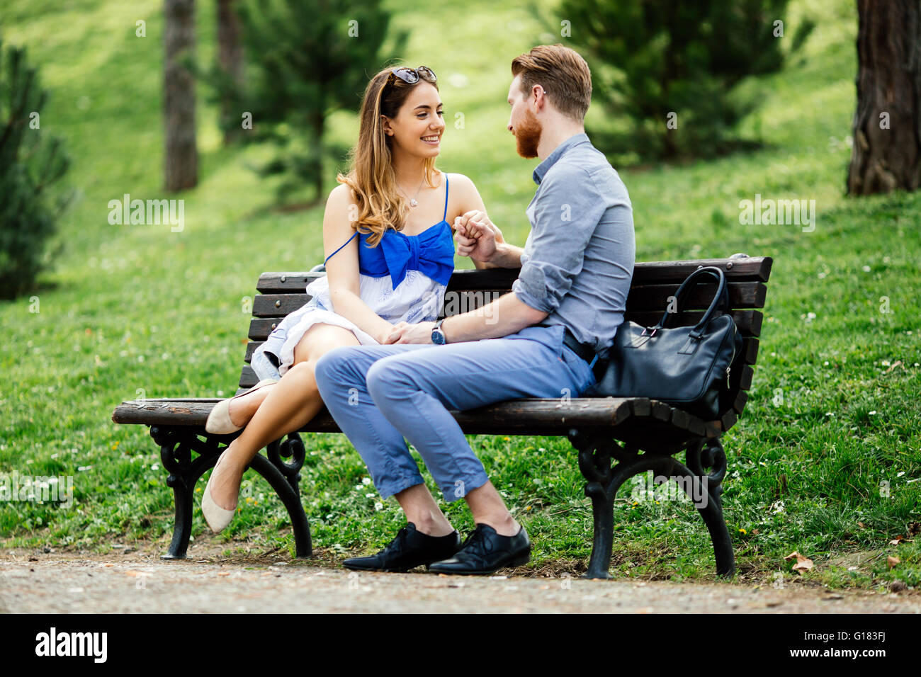 Romantic couple in park sitting on bench Stock Photo - Alamy