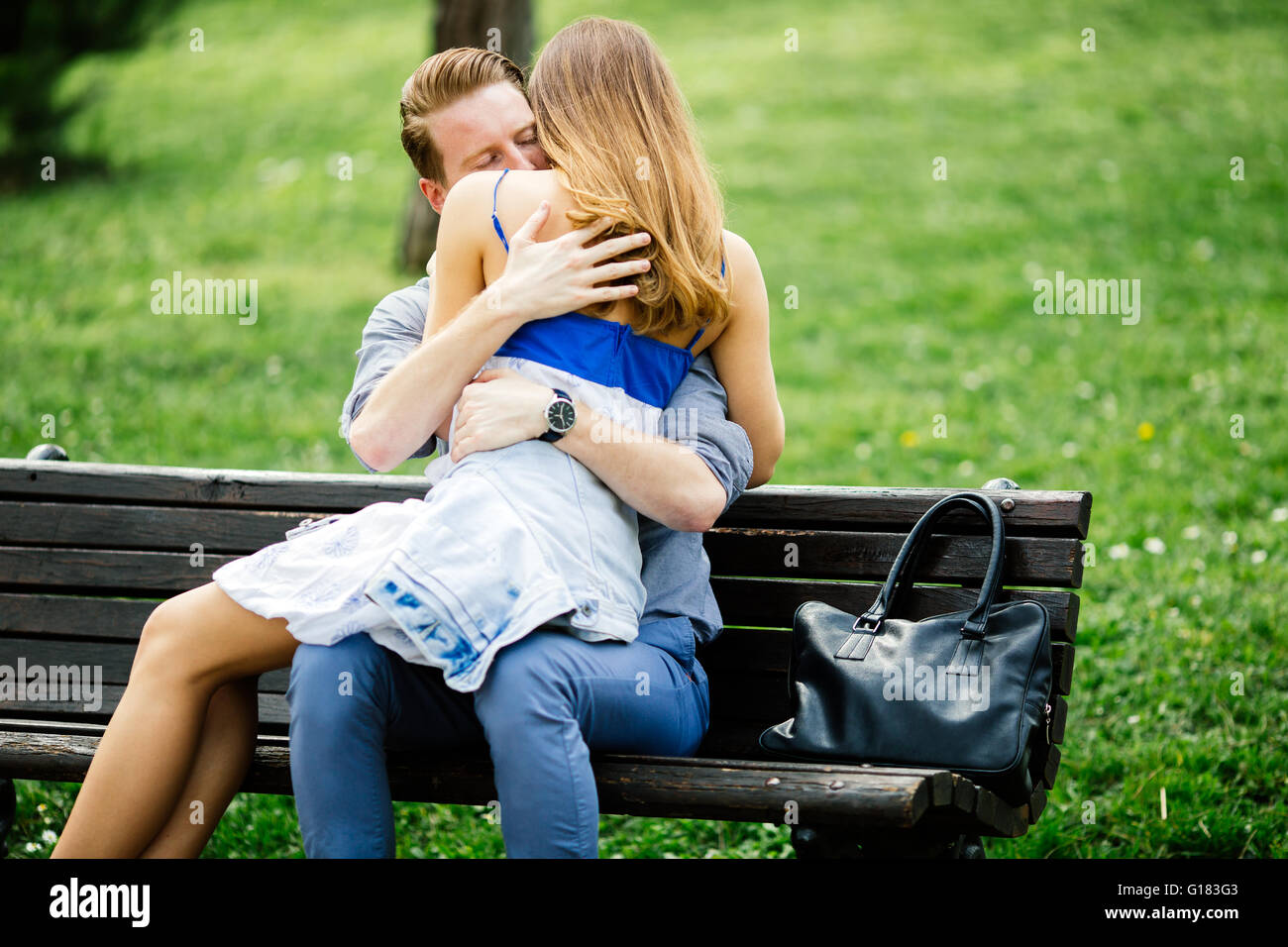 Couple hugging on park bench hi-res stock photography and images - Alamy