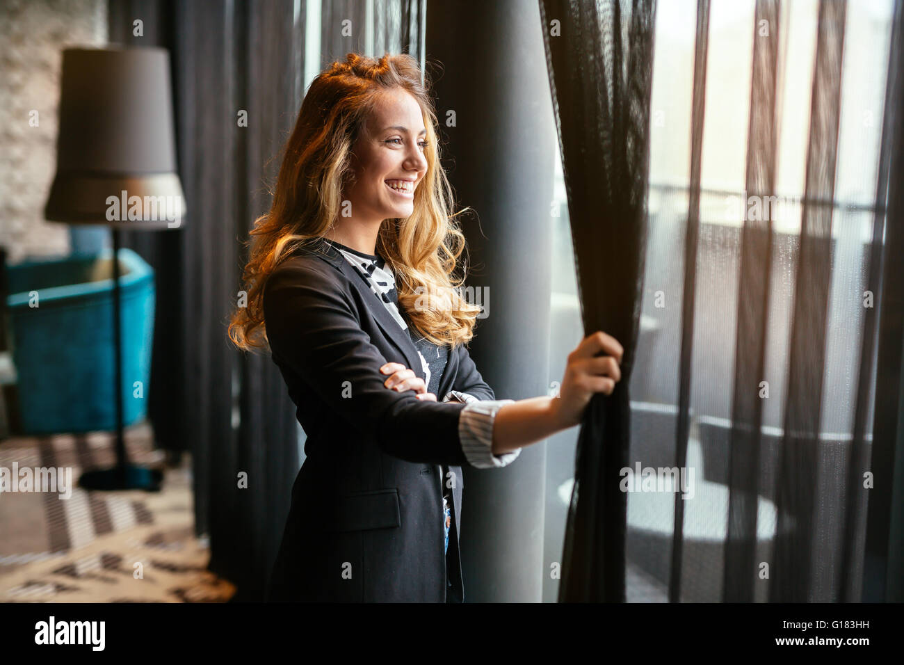 Glamorous happy woman staring through window Stock Photo - Alamy