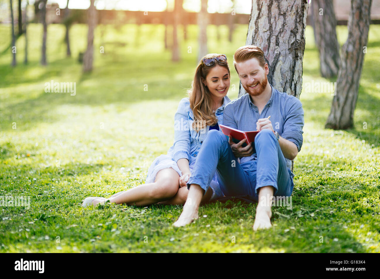 Beautiful couple studying together for exams in nature Stock Photo - Alamy