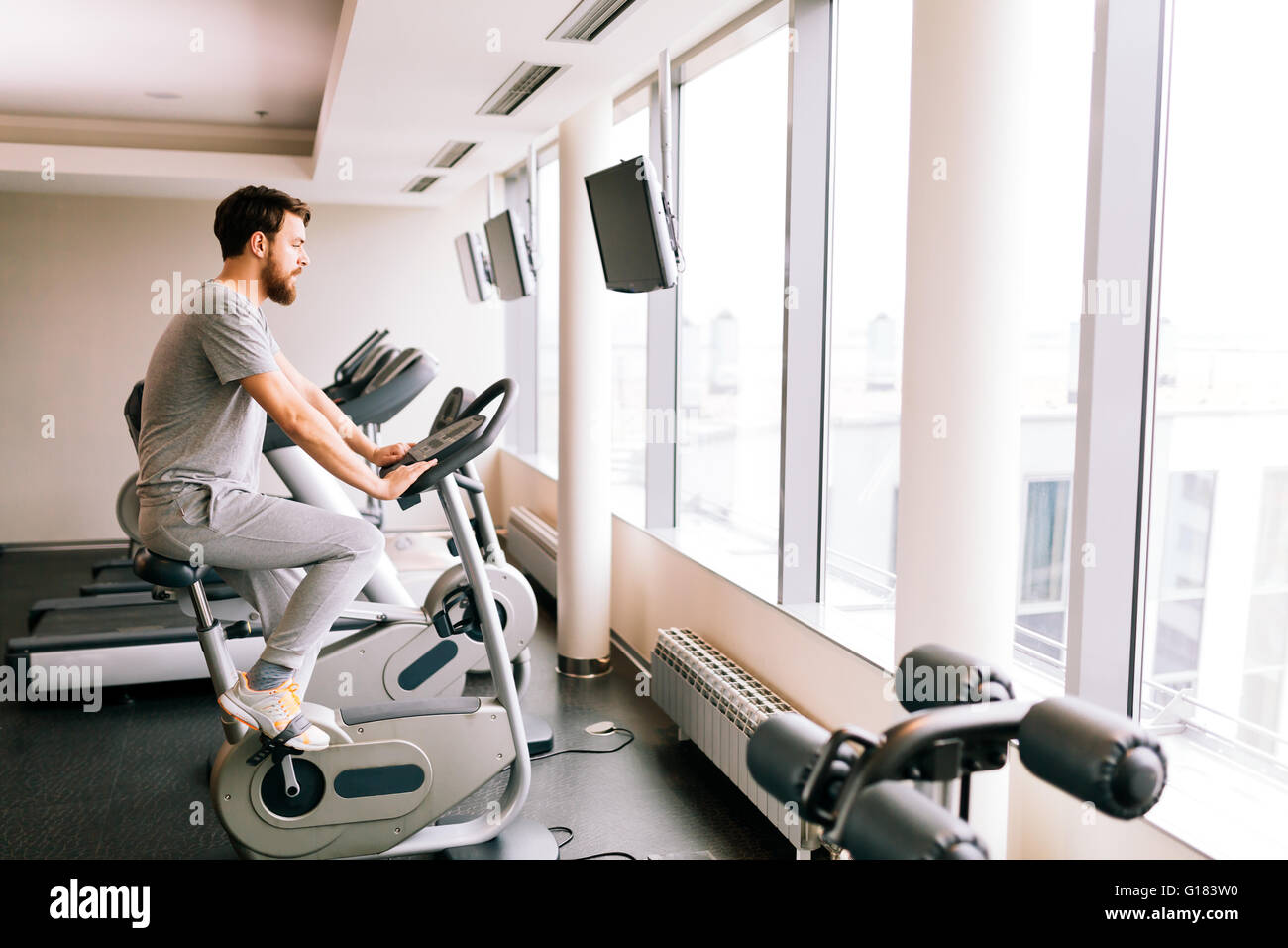 Man cardio training on a bicycle in a gym Stock Photo - Alamy
