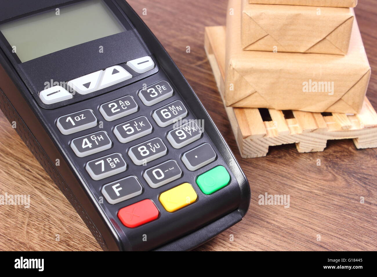 Credit card reader, payment terminal and small wrapped boxes on wooden ...