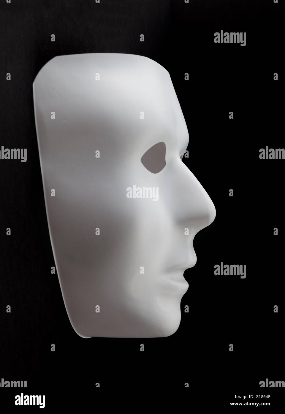 White mask emerging from black background Stock Photo - Alamy