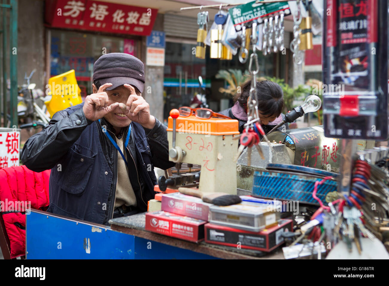 Portrait of a Chinese smiling man imitating a photo camera photographer ...