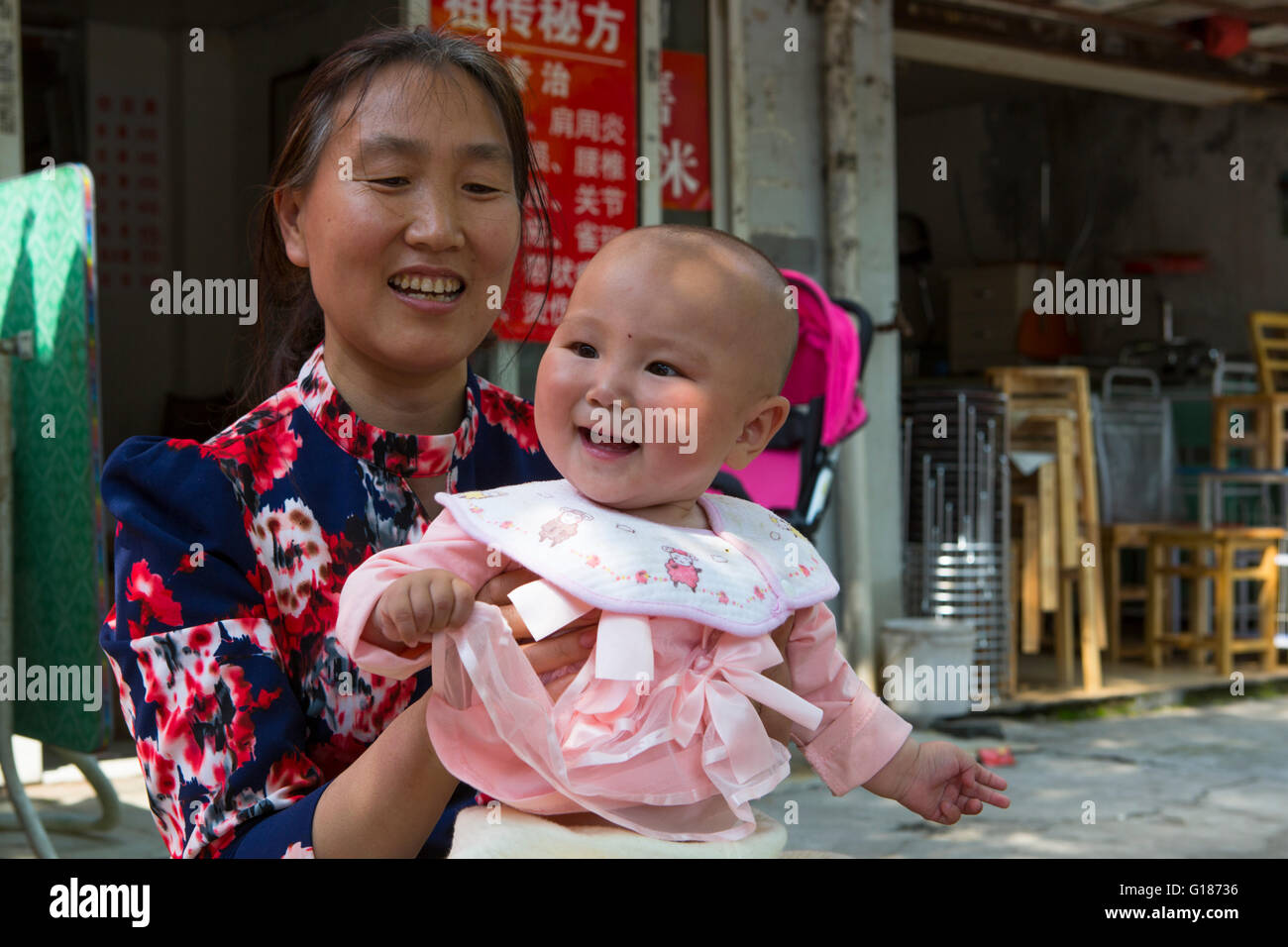 Proud Chinese mother with her happy adorable smiling baby daughter in a ...