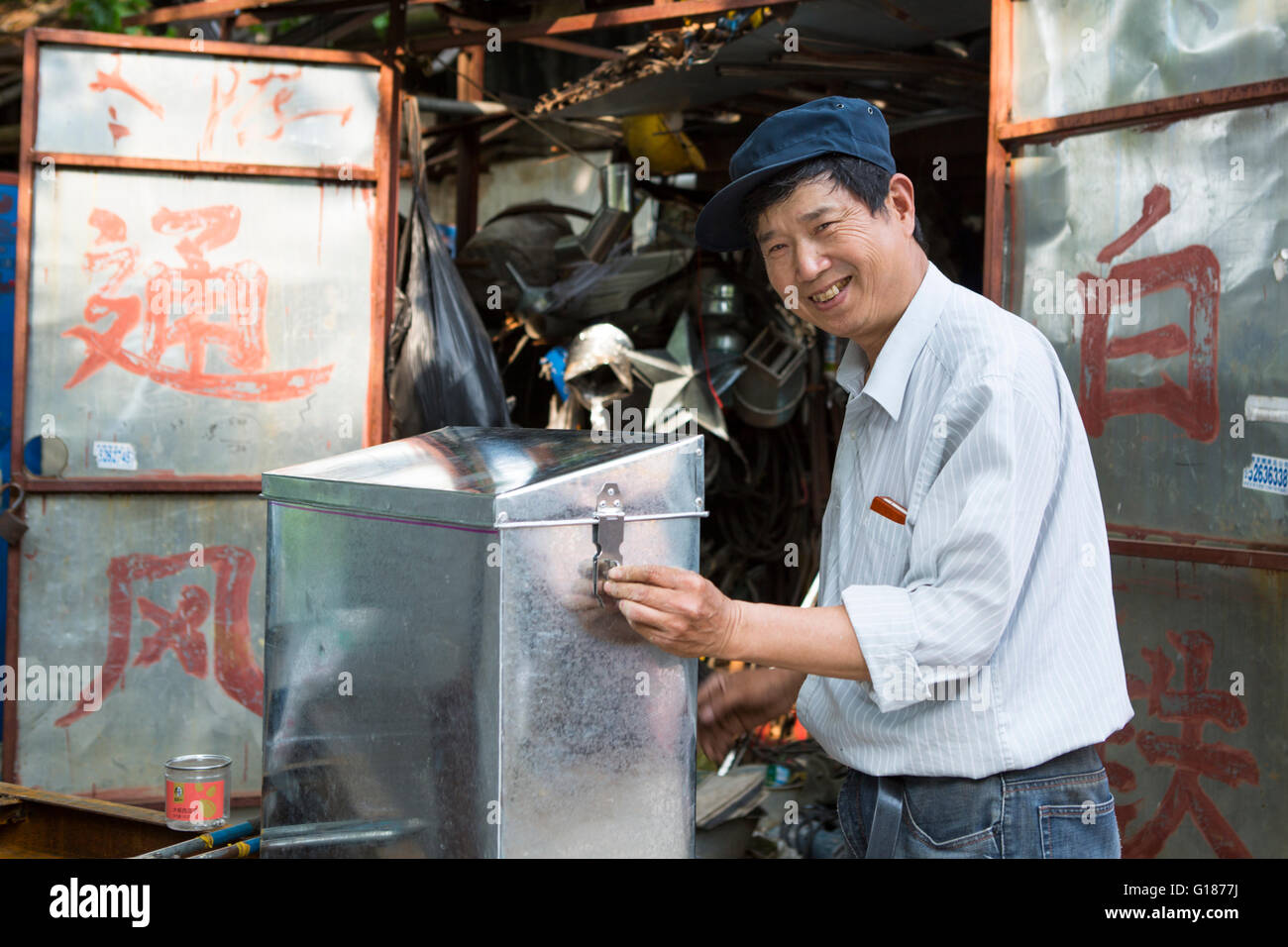 Proud Chinese craftsman and entrepreneur with blue shirt and blue cap ...