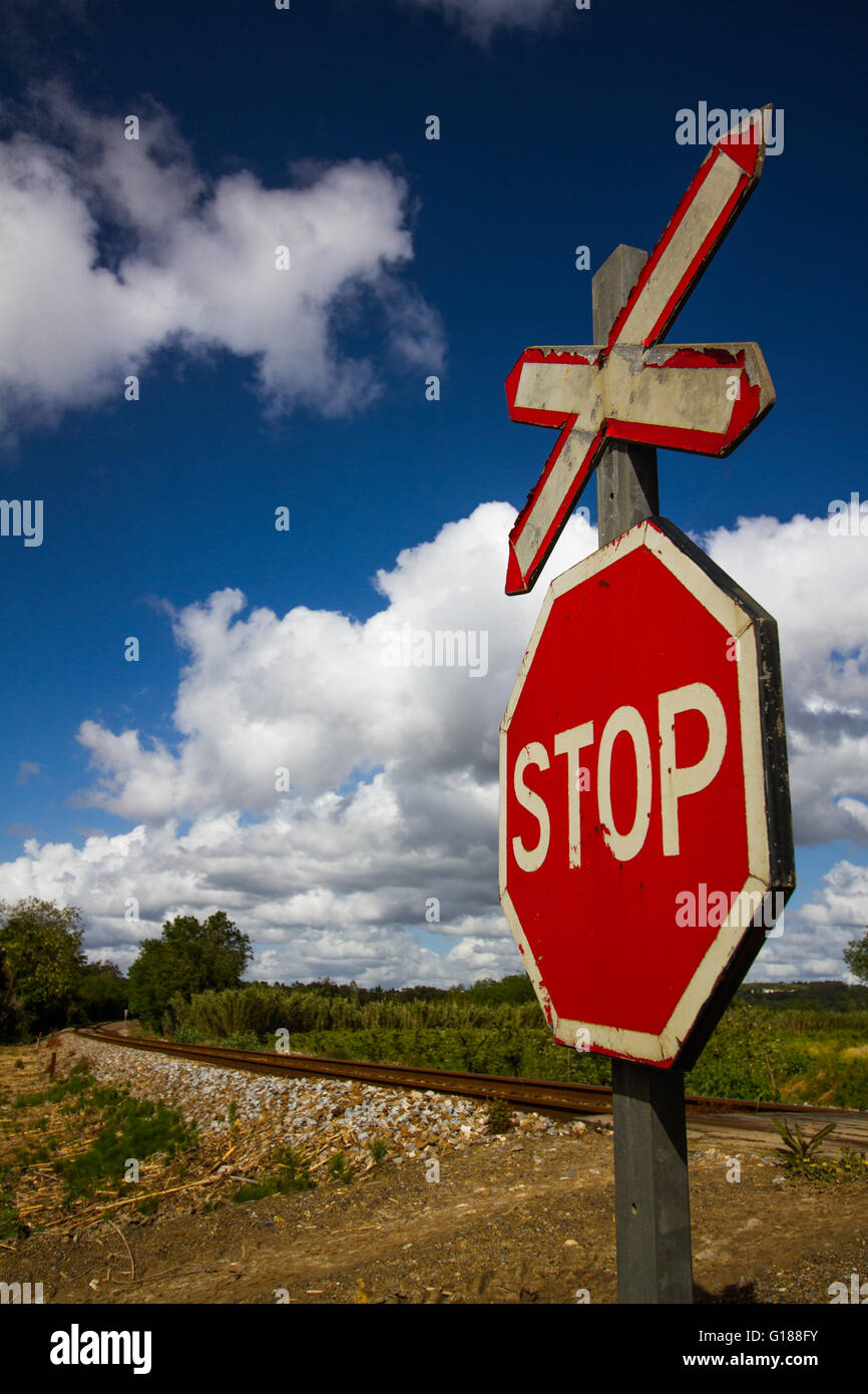 Stop sign on a railway crossroad during a sunny cloudy day Stock Photo ...