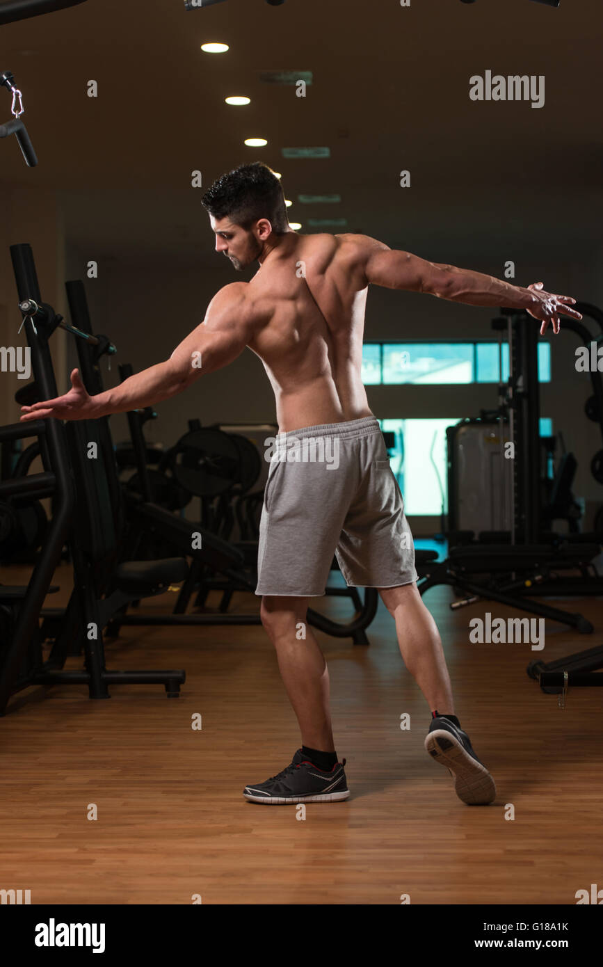 Young Man Standing Strong In The Gym And Flexing Muscles - Muscular ...