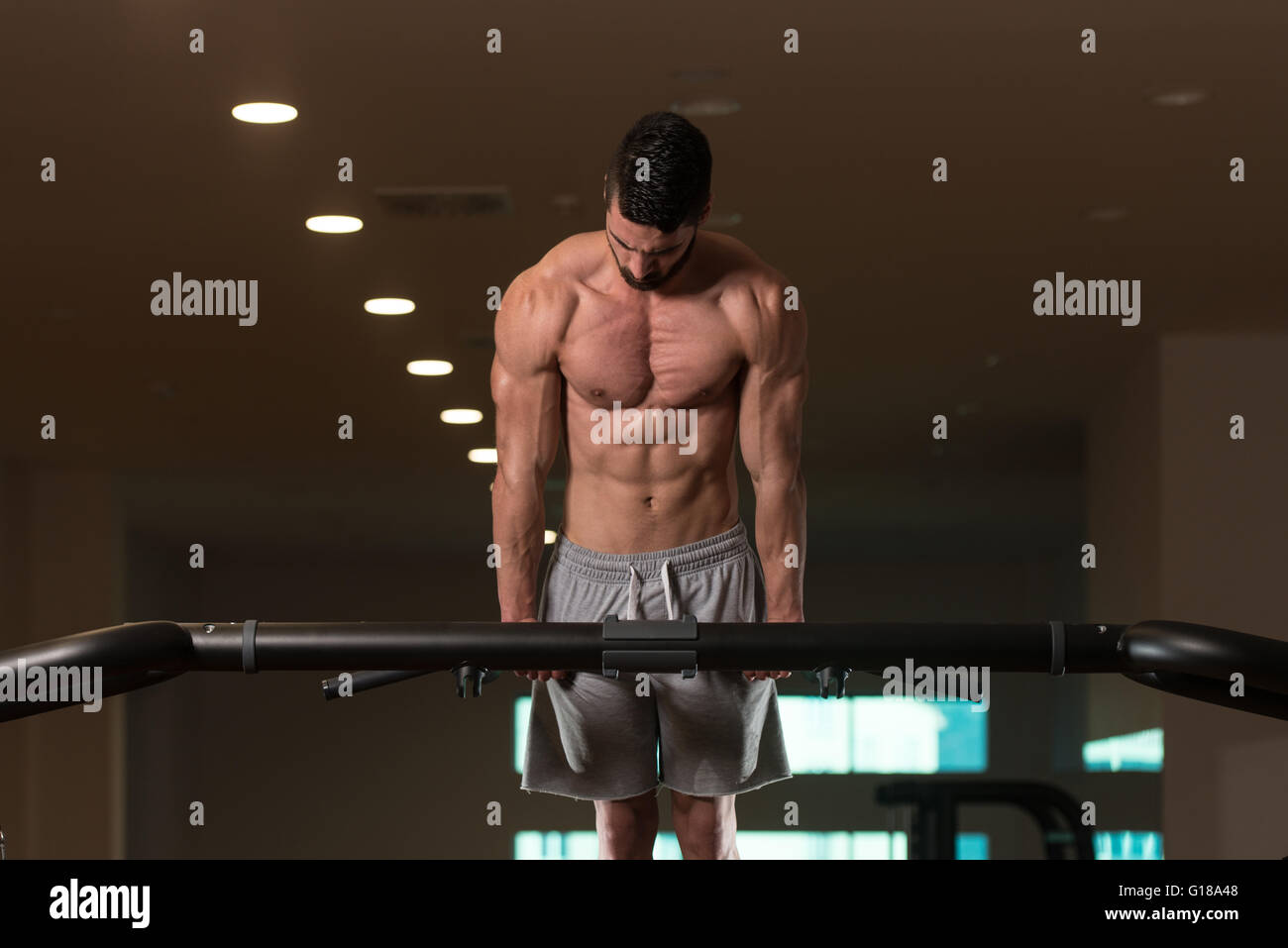Young Bodybuilder Doing Dips on Bar Exercising Triceps On Machine In ...