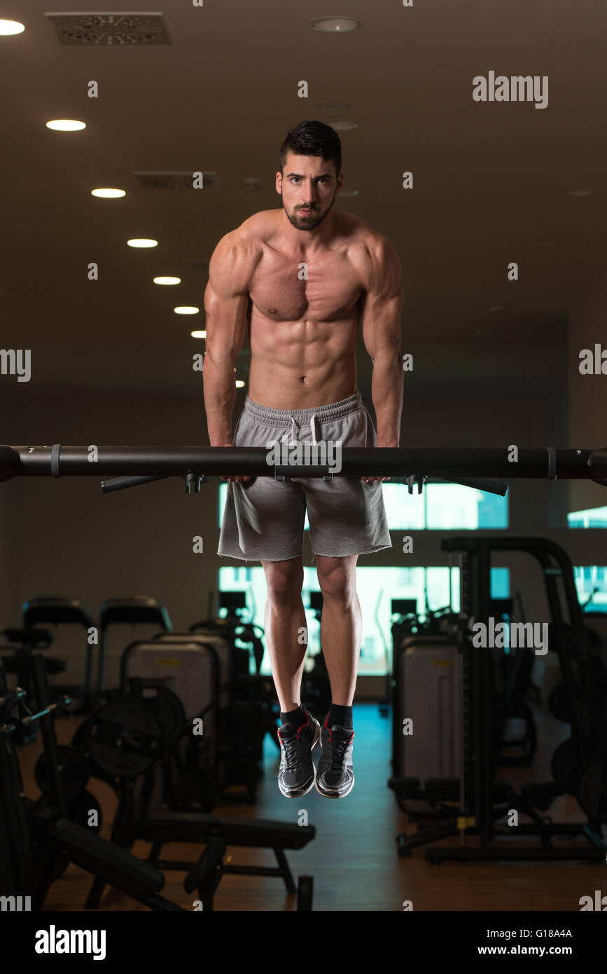 Young Bodybuilder Doing Dips on Bar Exercising Triceps On Machine In ...